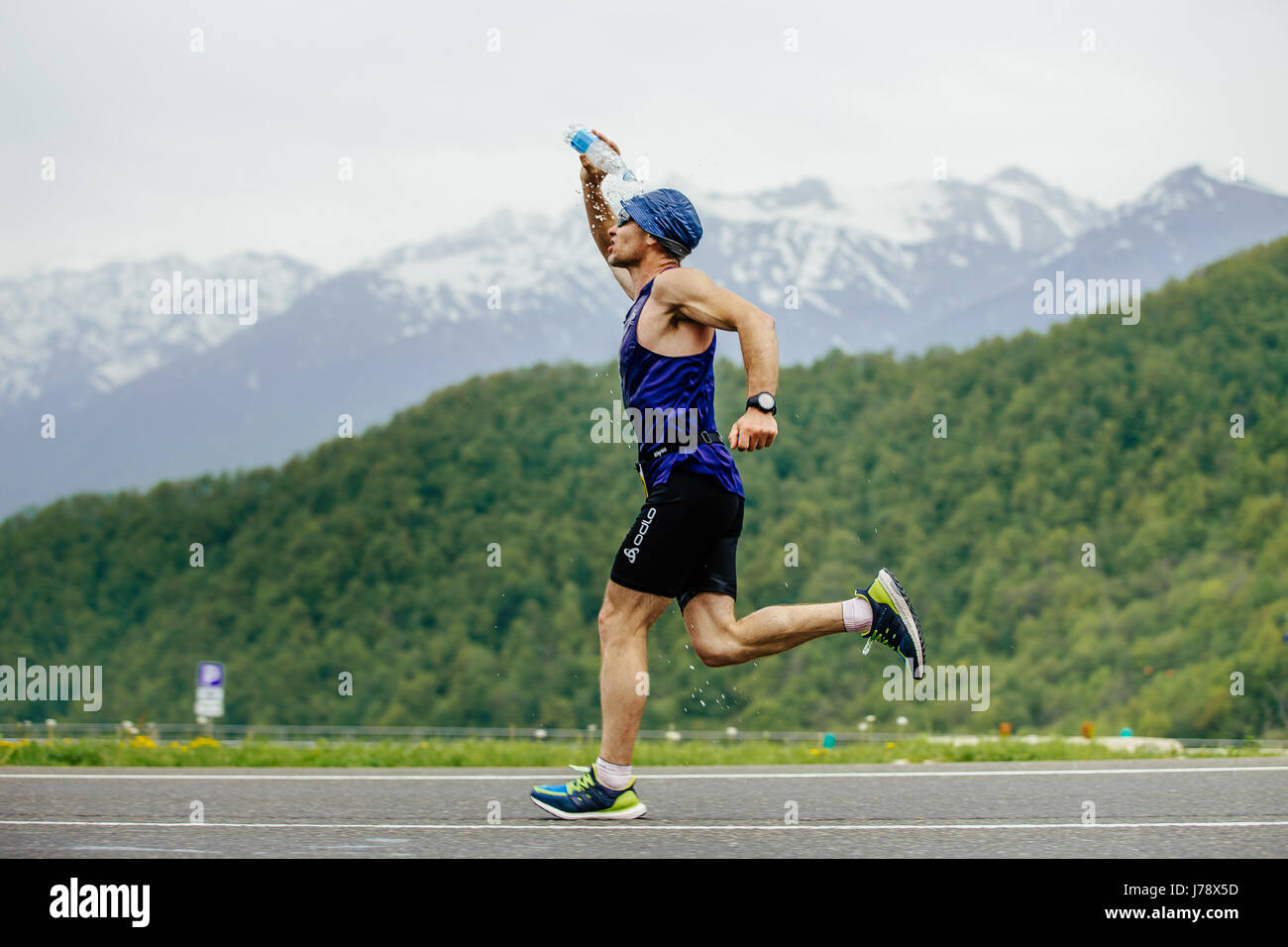 Rosa Khutor, Russia - May 7, 2017: man runner on water point pours face ...