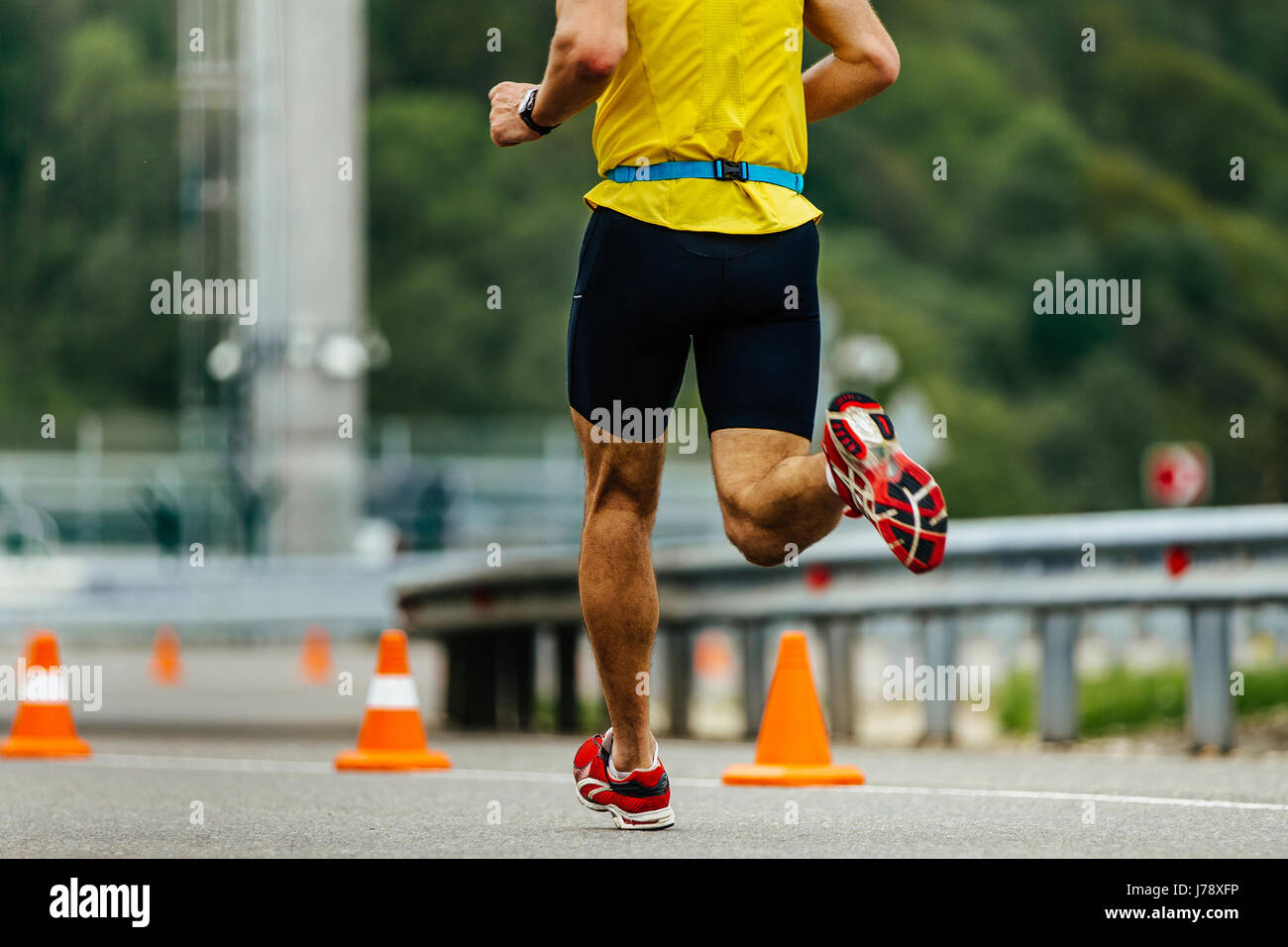 one male athletic runner running in roads with traffic cones safety ...