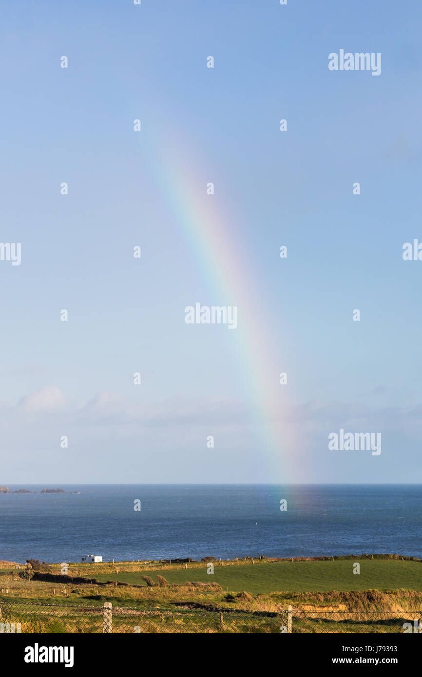 A Rainbow in rural Irish Countryside ending in the Irish Sea Stock ...