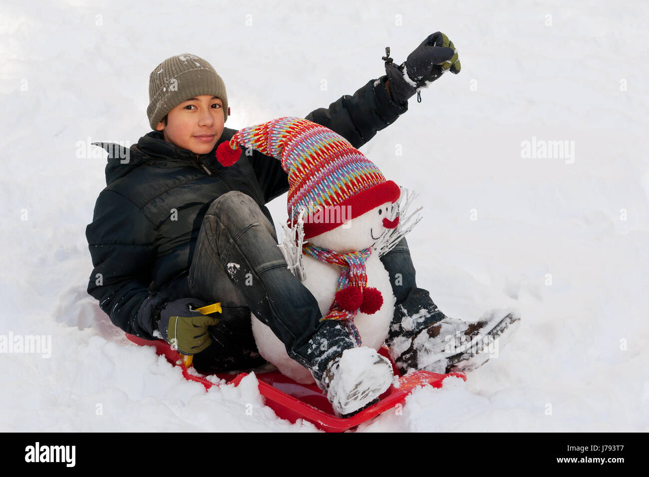 child with snowman and sled Stock Photo - Alamy