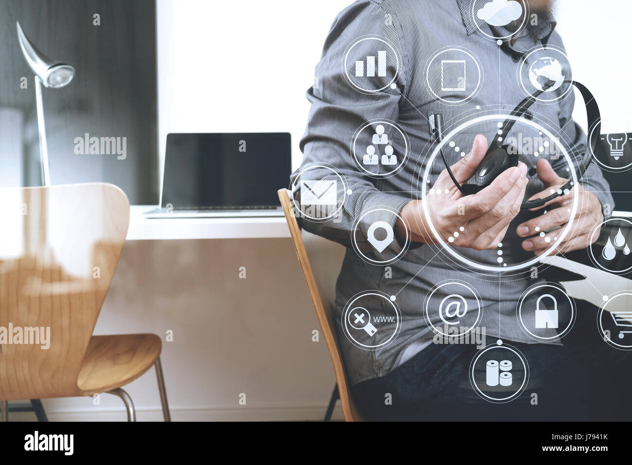 Man using VOIP headset with digital tablet and laptop computer as ...