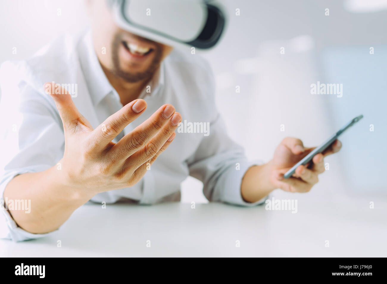 businessman wearing virtual reality goggles in modern office with ...