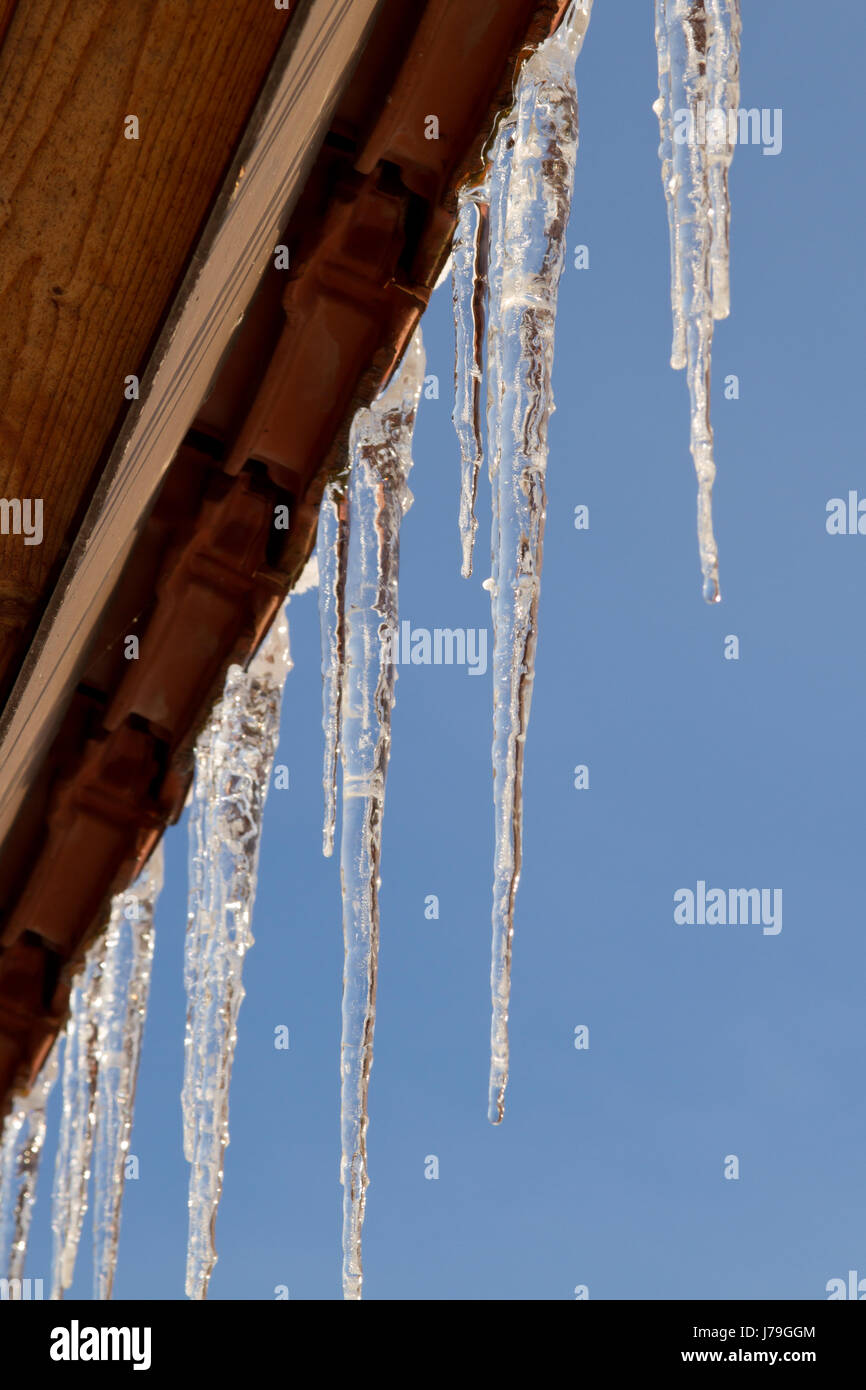 house building winter cold ice frozen icicle icicles rooftop blue tile ...