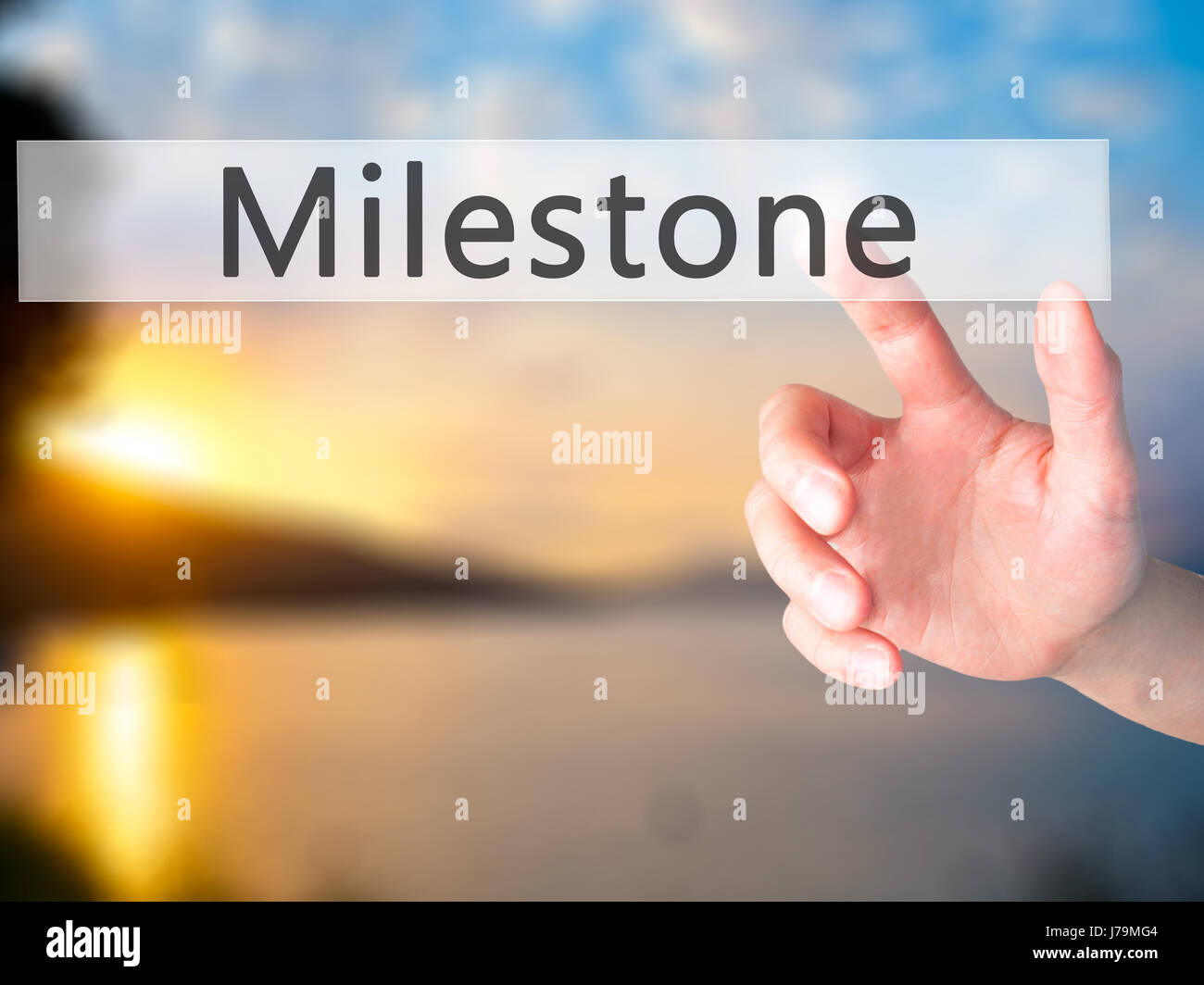 Milestone - Hand pressing a button on blurred background concept ...