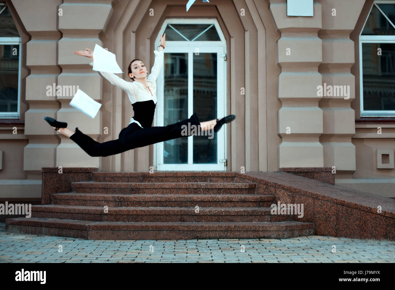 Girl running down the street tossing documents handed. She is jumps ...