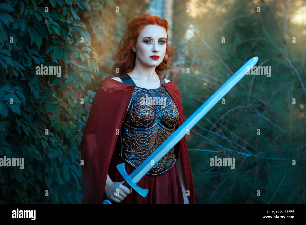 Beautiful girl holding a sword in his hand. She is an old-fashioned ...