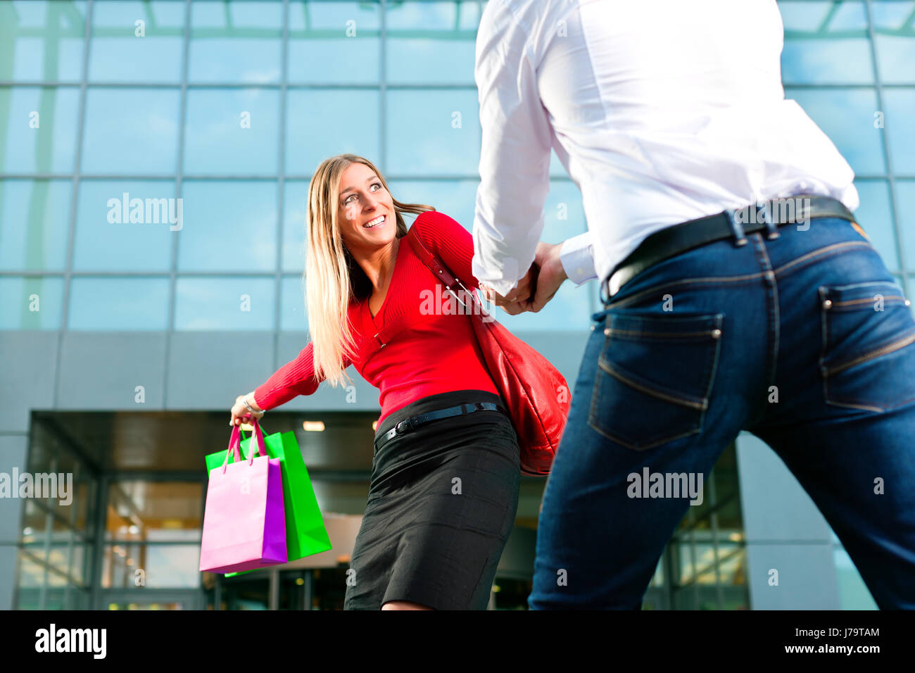 woman pulling man in shopping center Stock Photo - Alamy