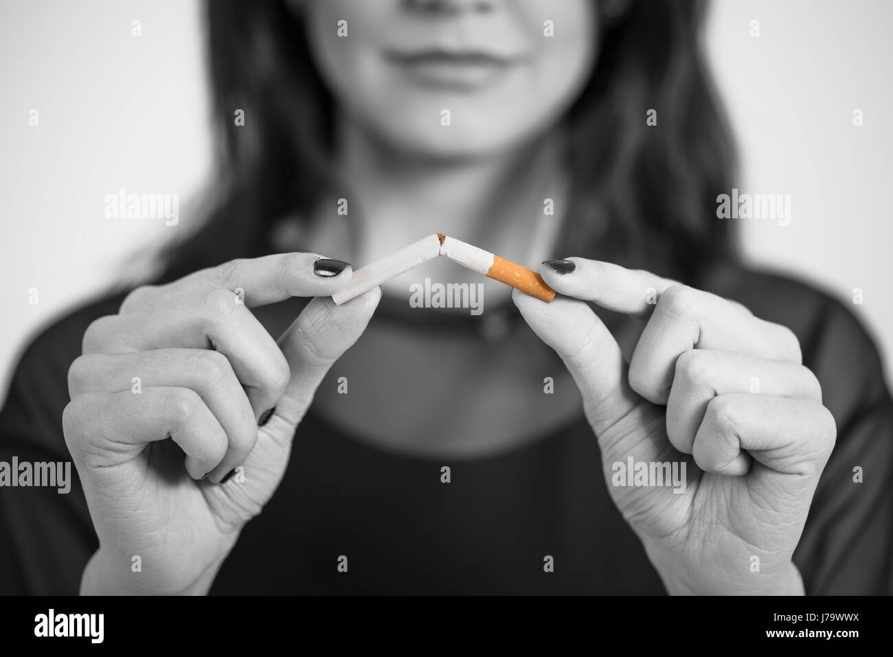 Close up portrait of young attractive woman breaking down cigarette to ...