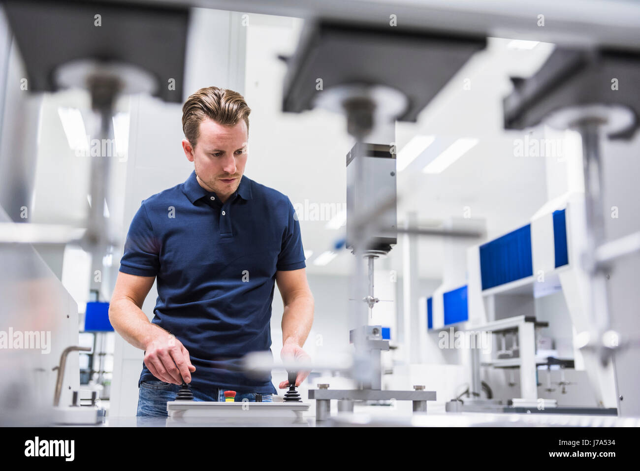 Man operating machine in testing instrument room Stock Photo - Alamy