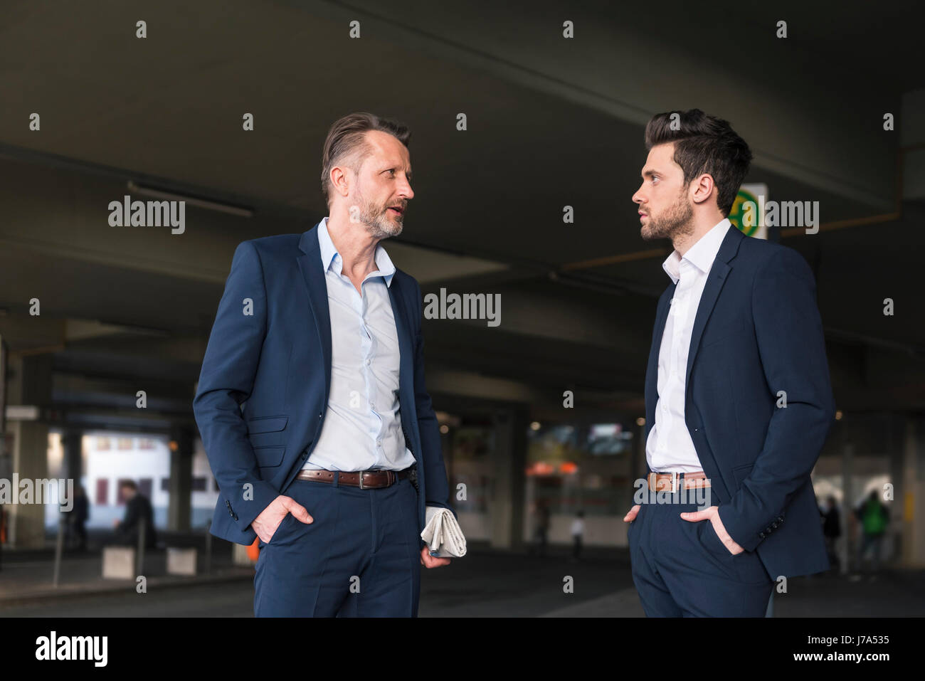 Two businessmen waiting at bus terminal Stock Photo - Alamy
