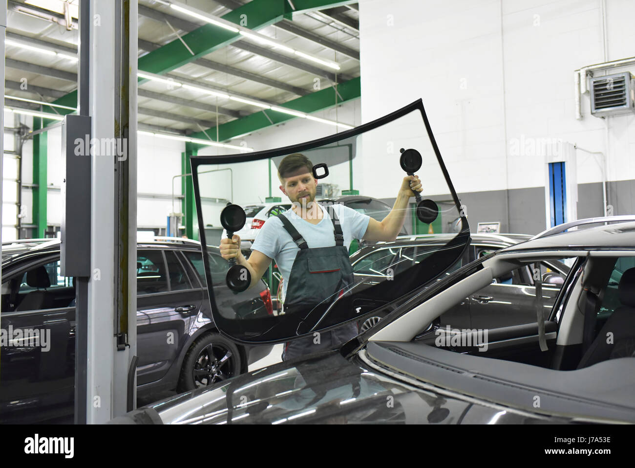 Car mechanic in a workshop changing car window Stock Photo - Alamy
