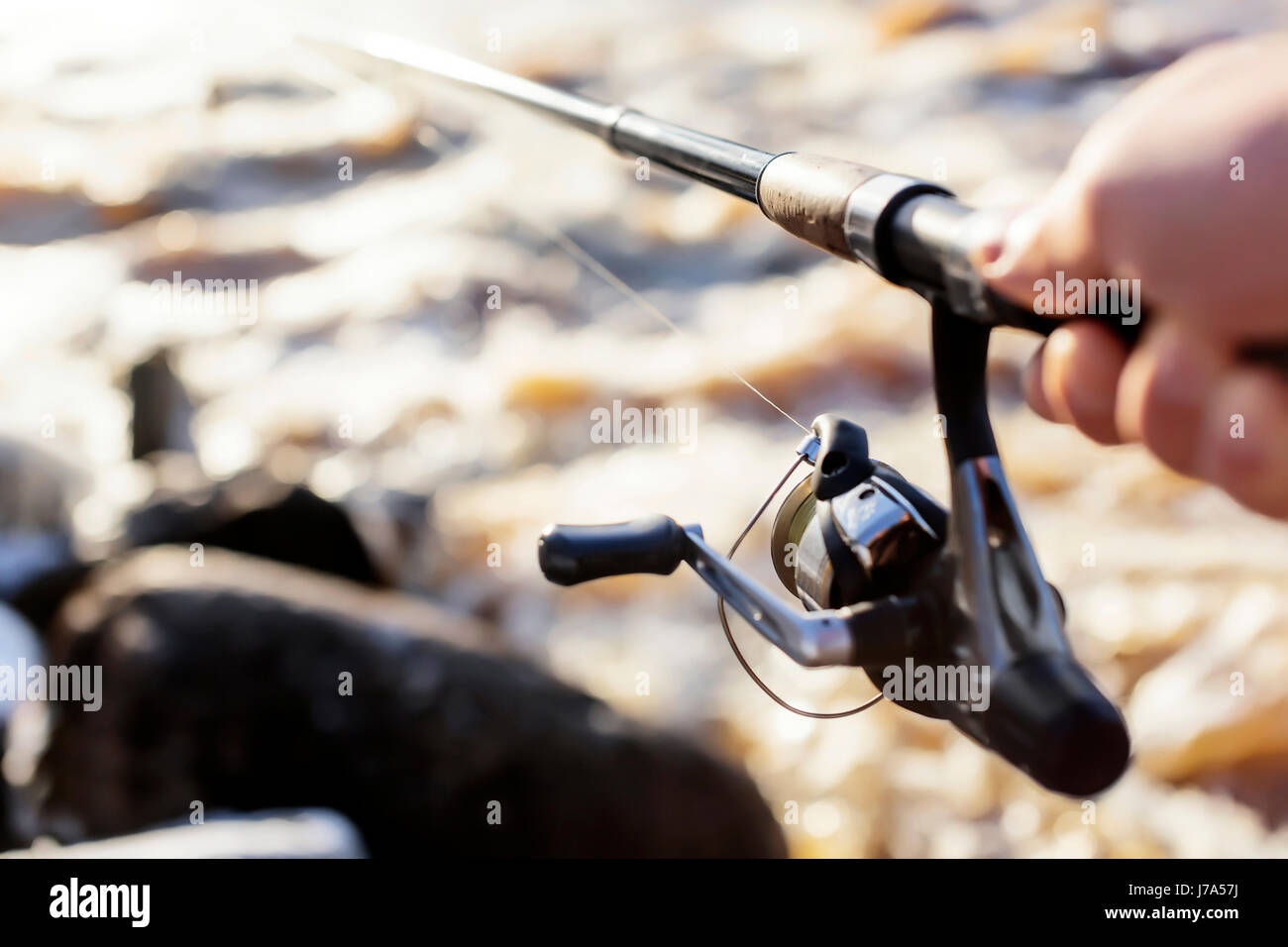 Hand holding fishing rod Stock Photo - Alamy