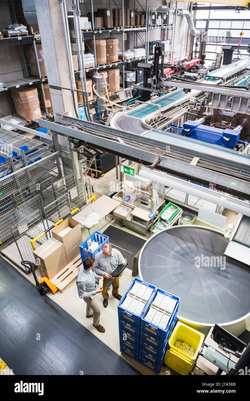 Top view of two men talking in factory shop floor Stock Photo - Alamy