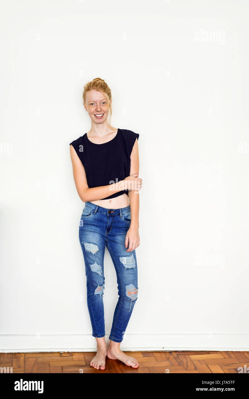 Ginger woman standing against white wall Stock Photo - Alamy