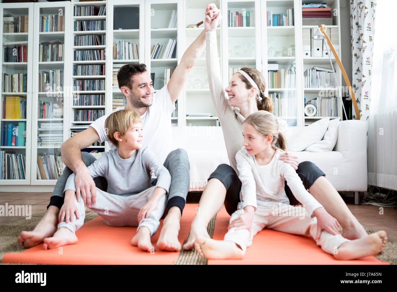 Happy family doing gymnastics at home Stock Photo - Alamy