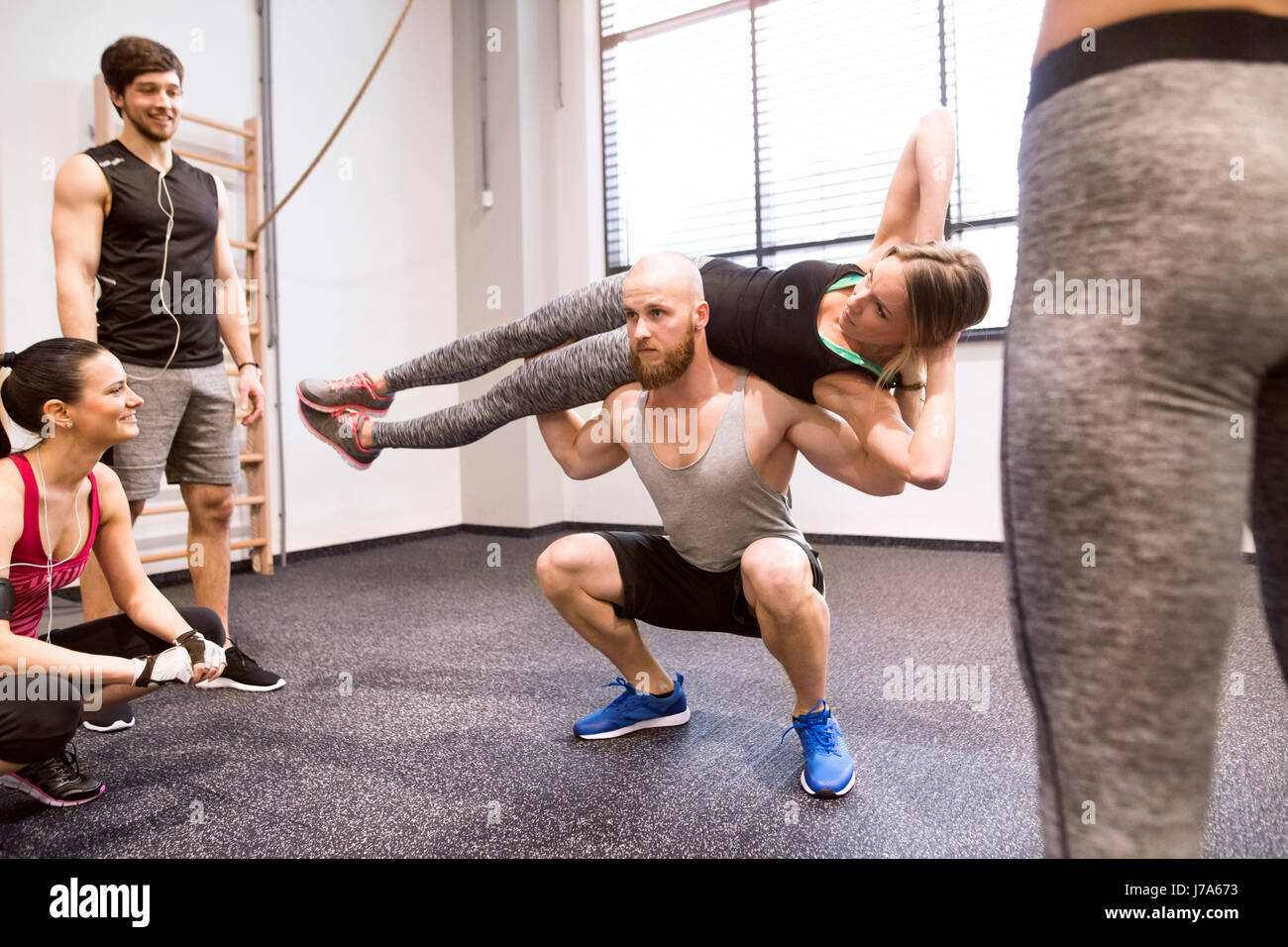 Young people doing fitness training in gym, lifting partners Stock ...