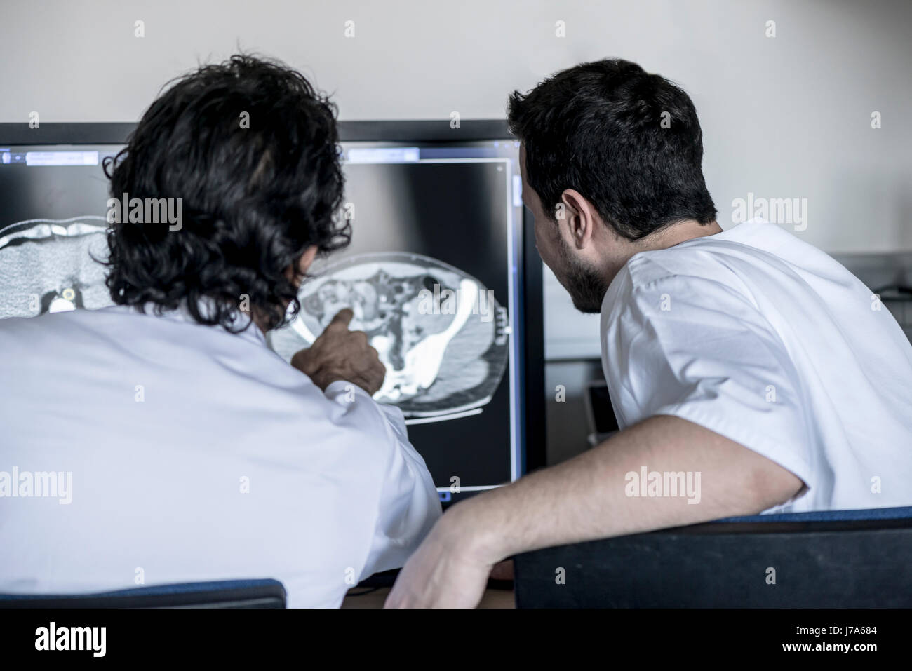 Two doctors discussing x-ray image on computer screen Stock Photo - Alamy
