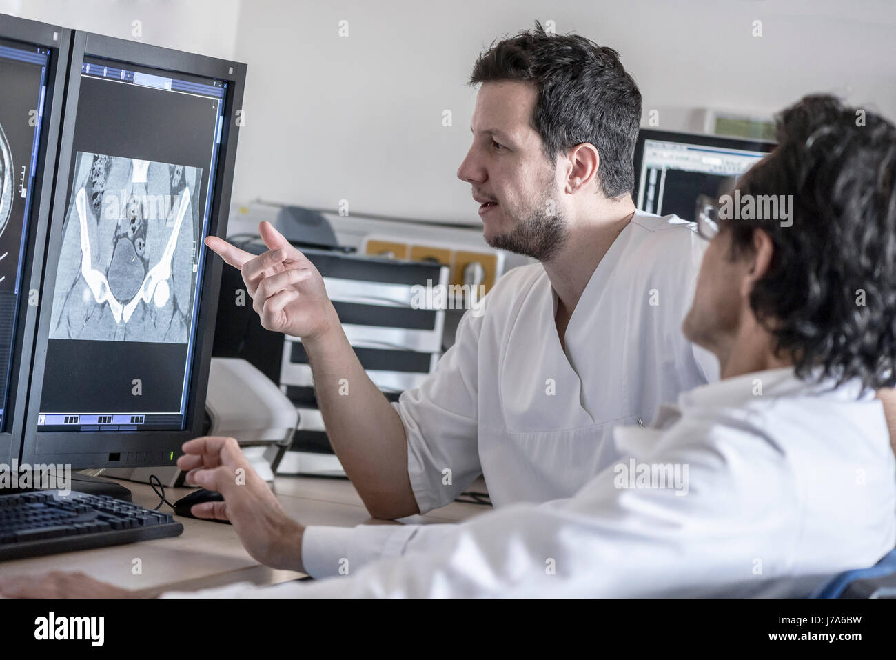 Two doctors discussing x-ray image on computer screen Stock Photo - Alamy