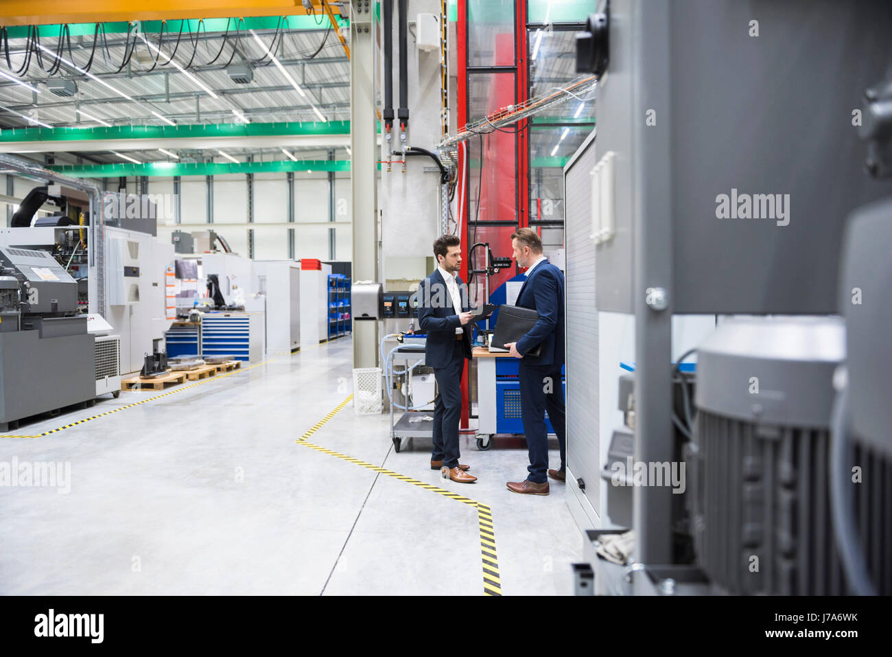 Two businessmen in factory shop floor Stock Photo - Alamy