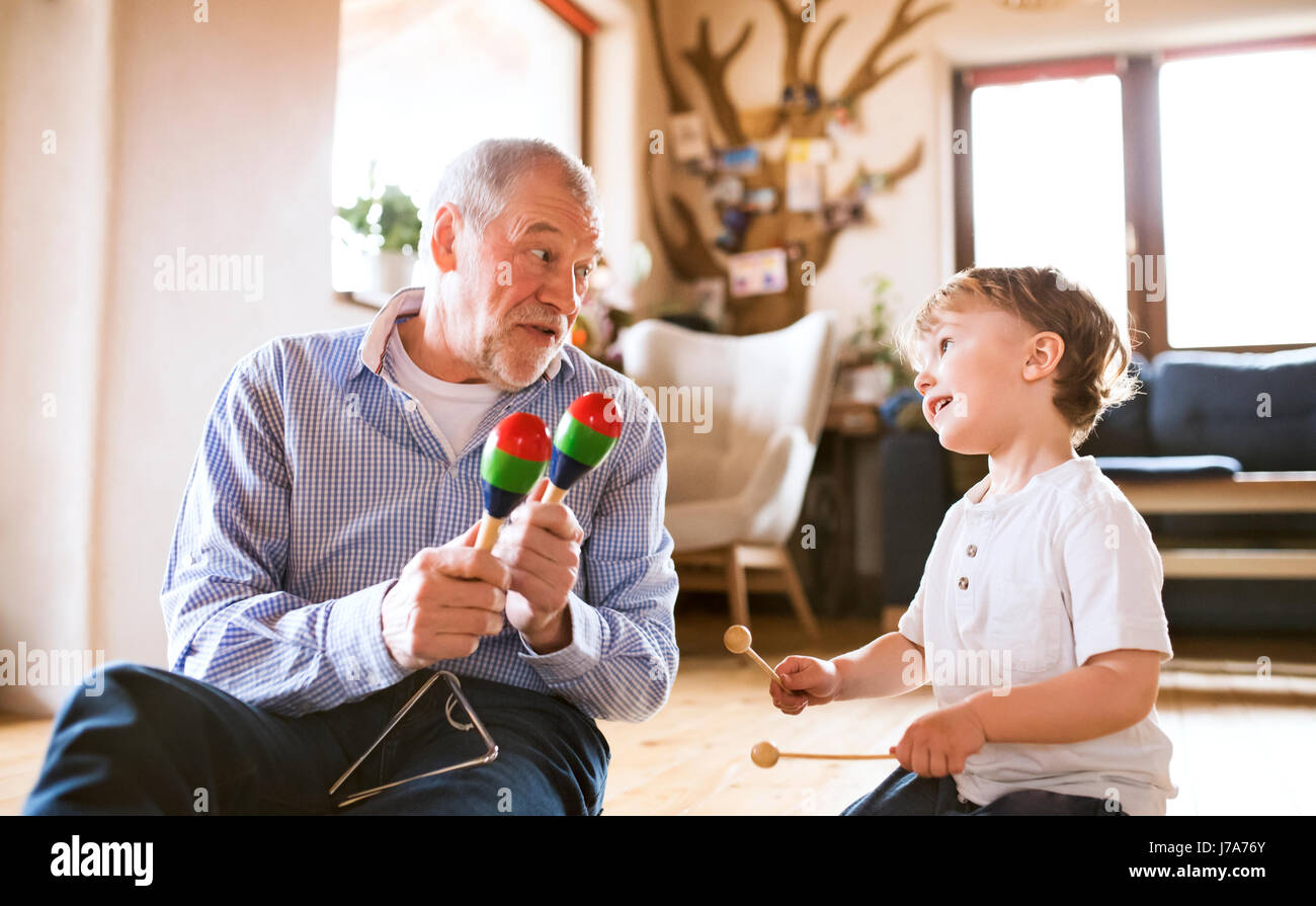 Grandfather and grandson playing music at home Stock Photo - Alamy