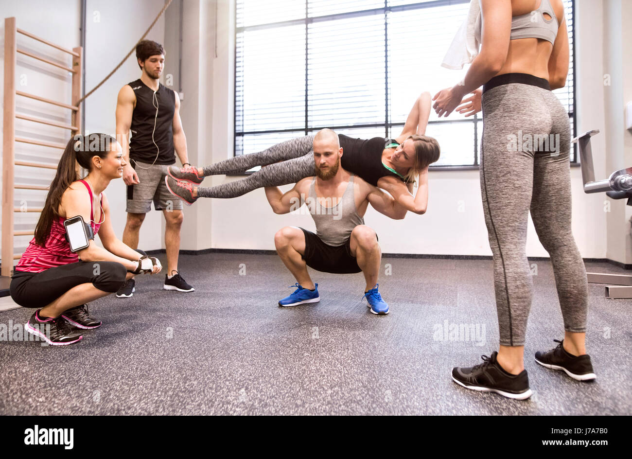 Young people doing fitness training in gym, lifting partners Stock ...