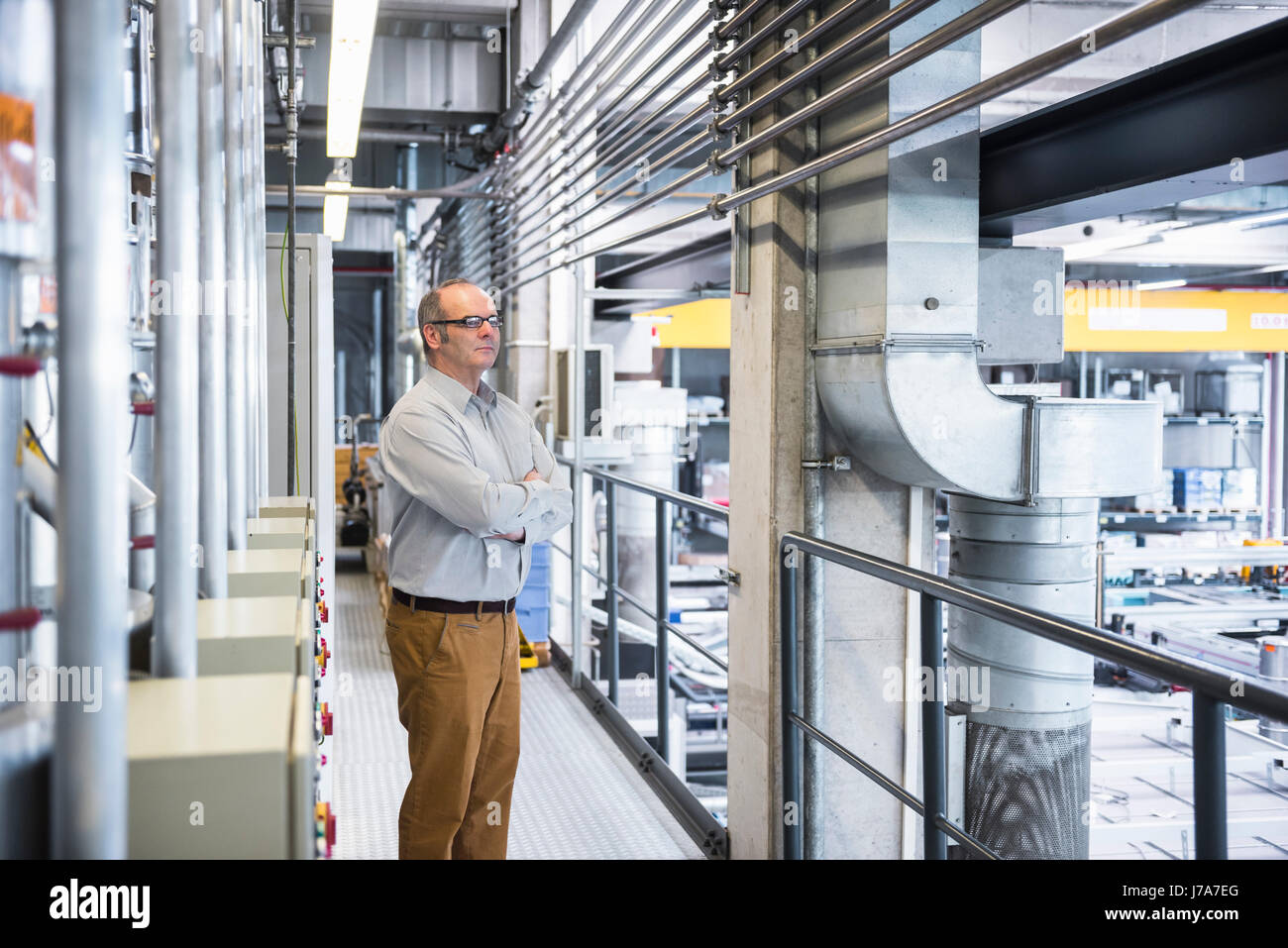 Manager looking over factory shop floor Stock Photo - Alamy