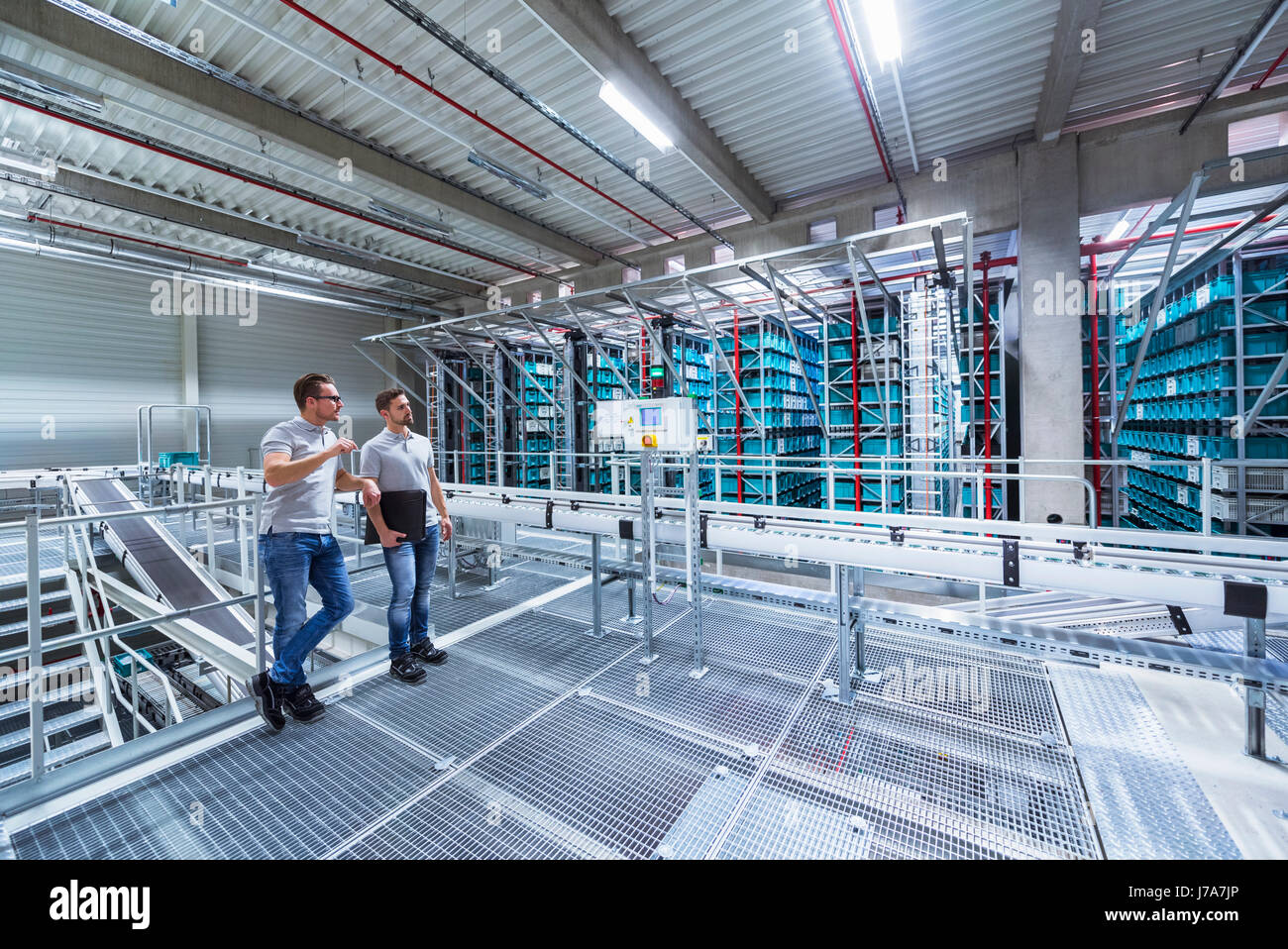 Two men in automatized high rack warehouse Stock Photo - Alamy