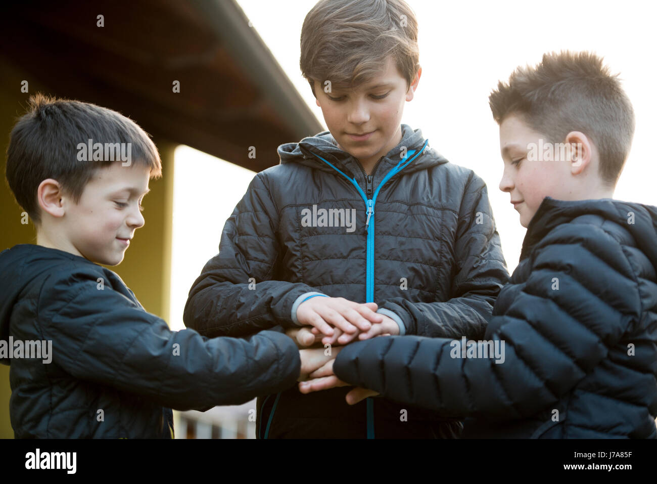 Three friends joining hands Stock Photo - Alamy