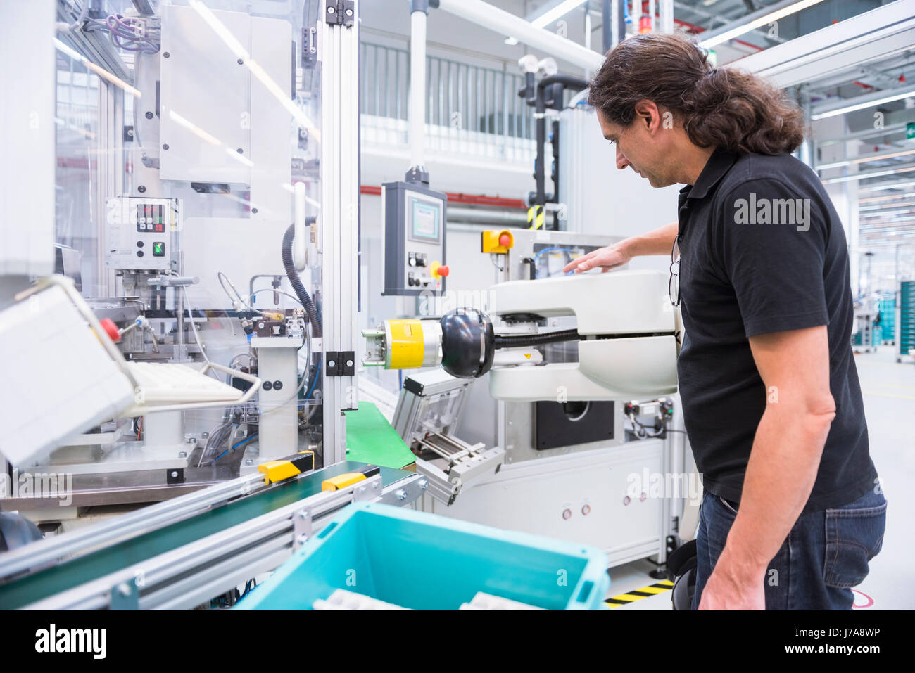 Man with assembly robot in factory Stock Photo - Alamy