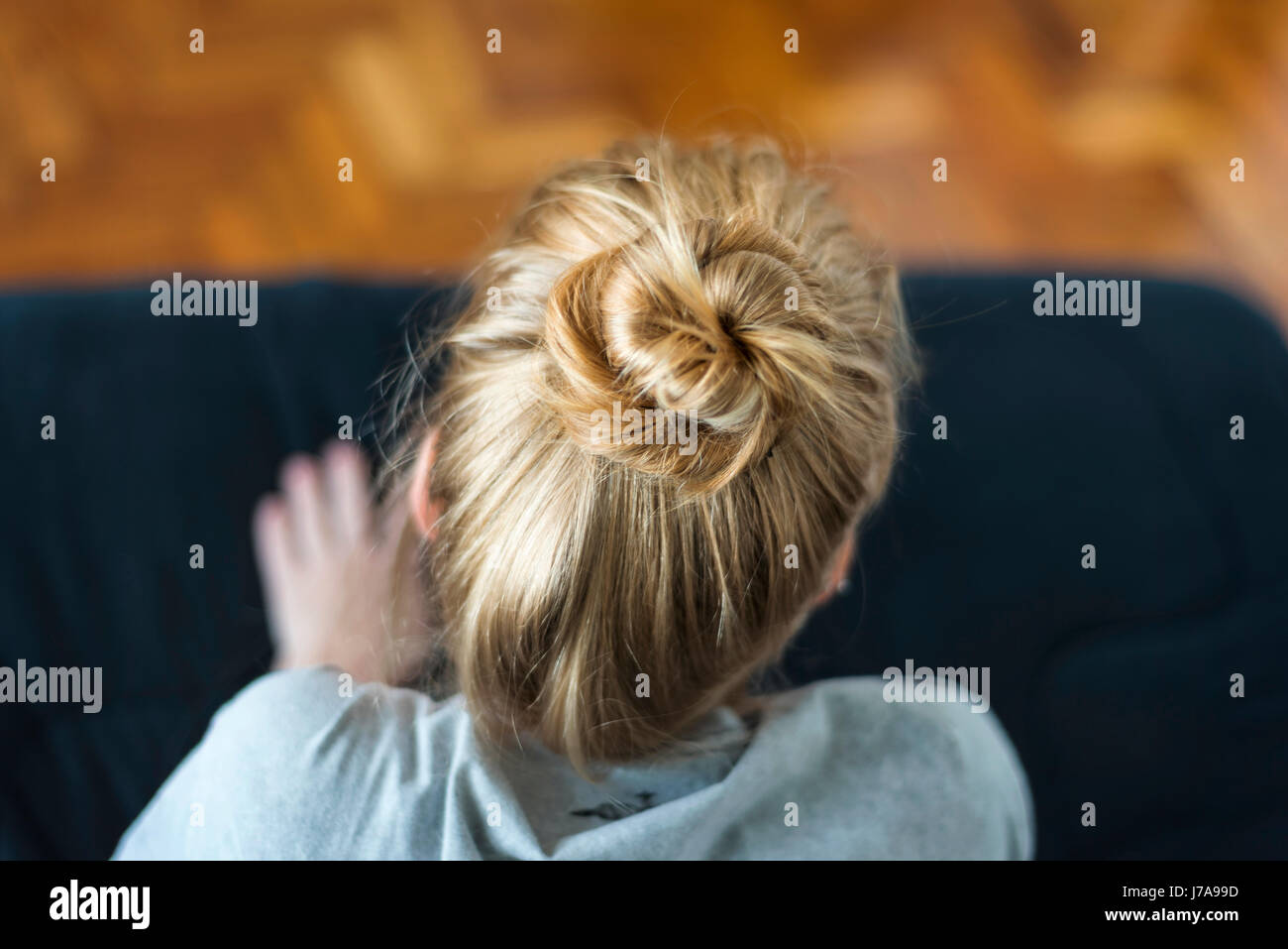 Woman with ginger hair bun sitting on sofa Stock Photo - Alamy