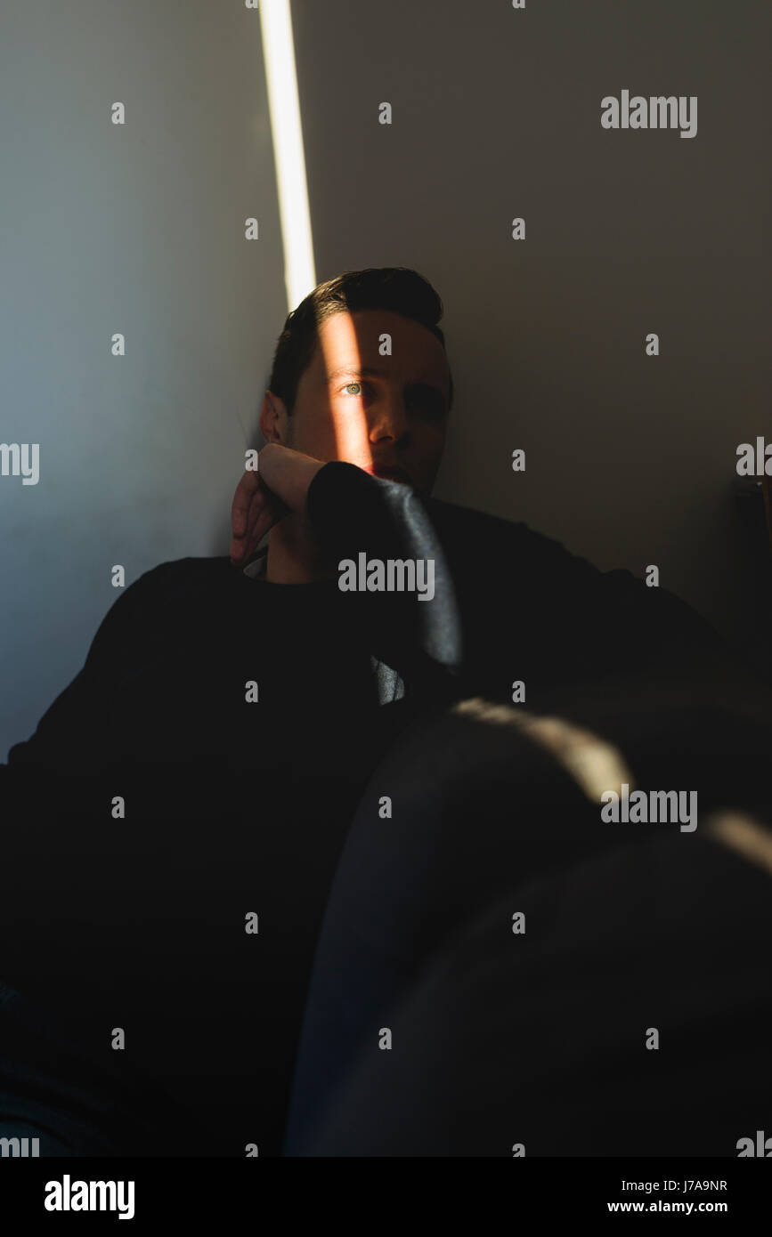 Man hiding in the shadow of his room at home Stock Photo - Alamy