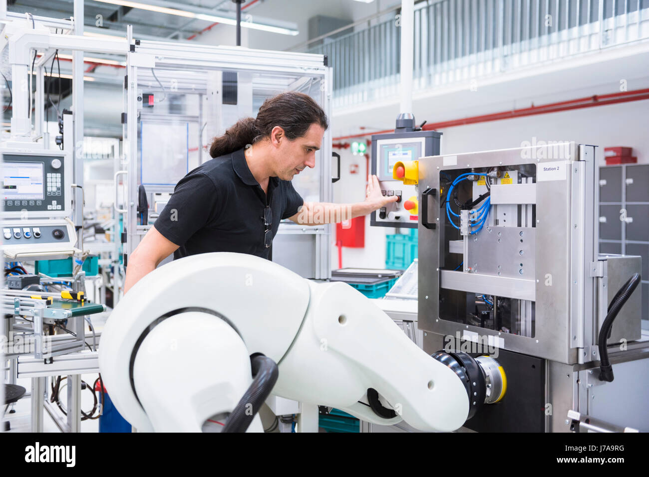 Man with assembly robot in factory Stock Photo - Alamy