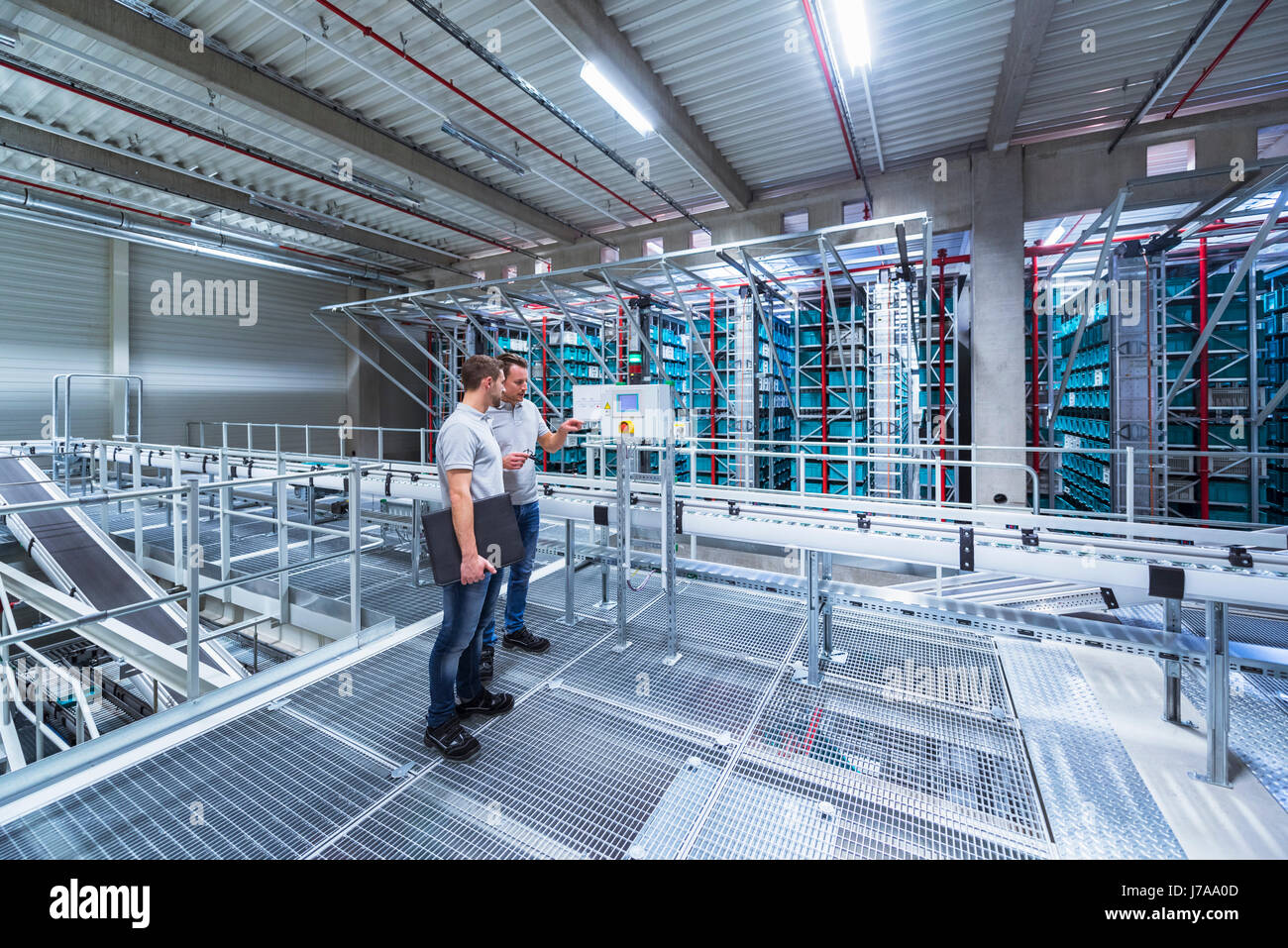 Two men in automatized high rack warehouse Stock Photo - Alamy