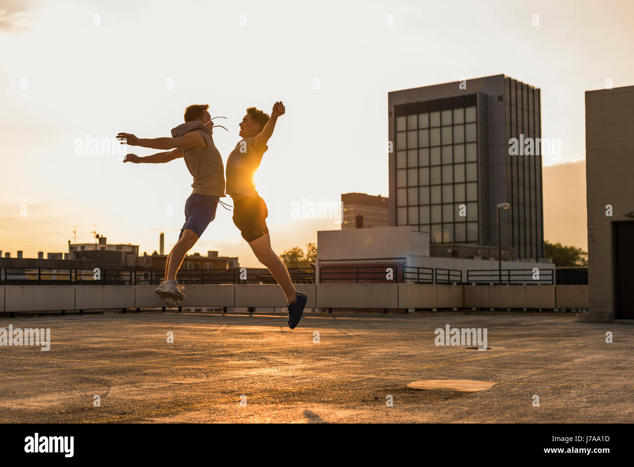 Friends jumping for joy at sunset Stock Photo - Alamy