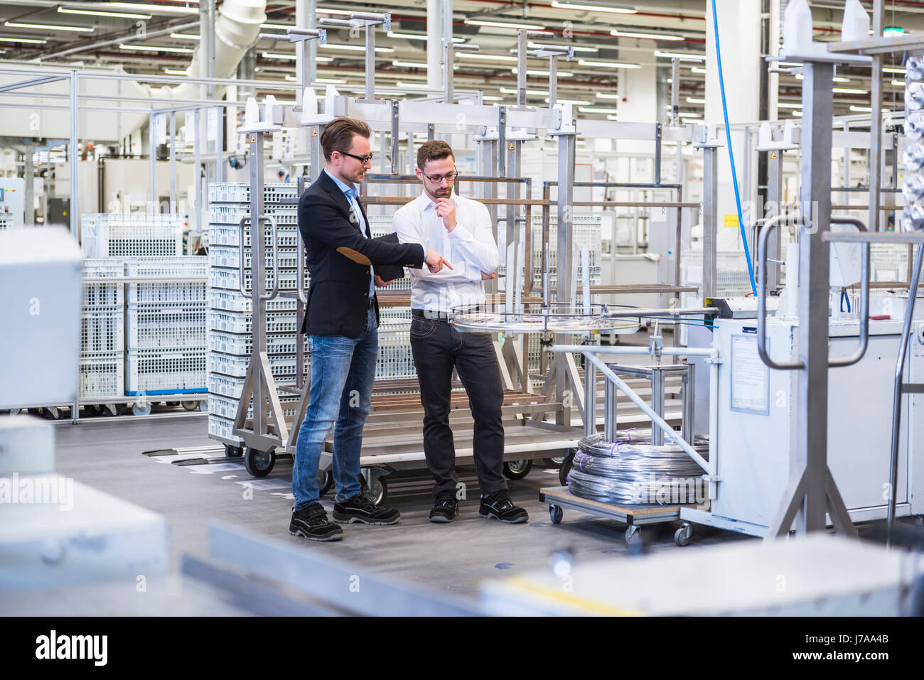 Two men talking in factory shop floor Stock Photo - Alamy