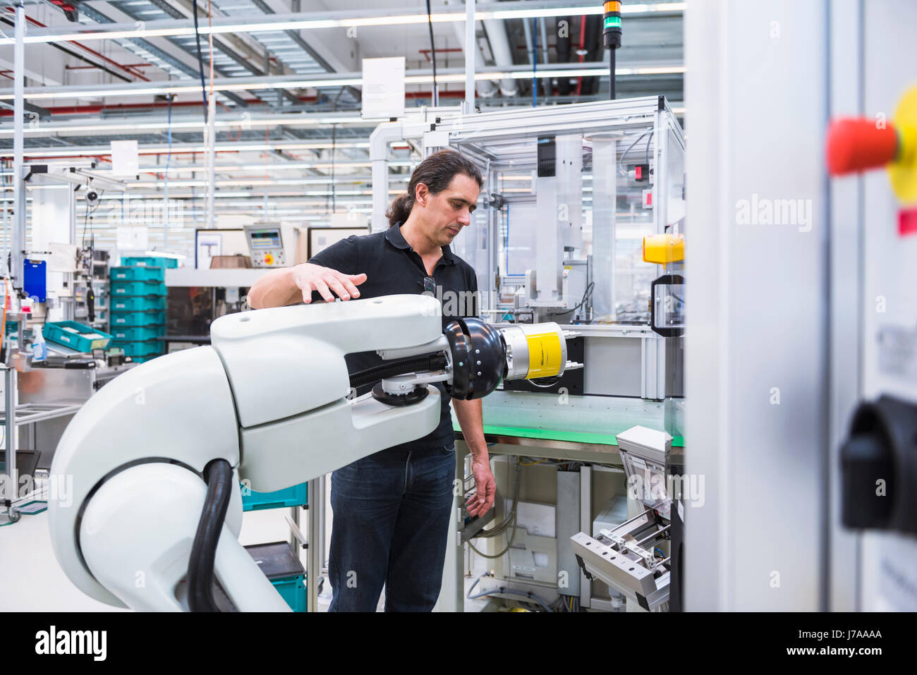 Man with assembly robot in factory Stock Photo - Alamy