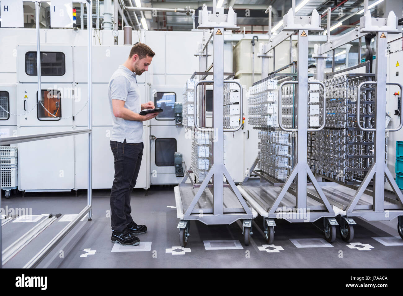 Man using tablet in factory shop floor Stock Photo - Alamy
