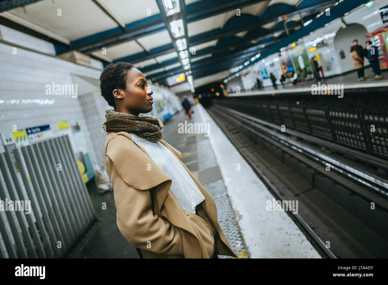 Young woman waiting at subway station platform Stock Photo - Alamy