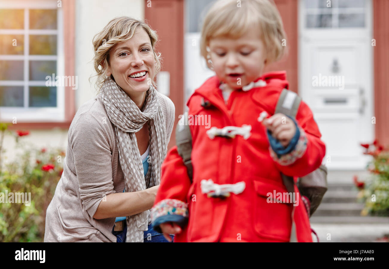 Mother looking after daughter leaving house Stock Photo - Alamy