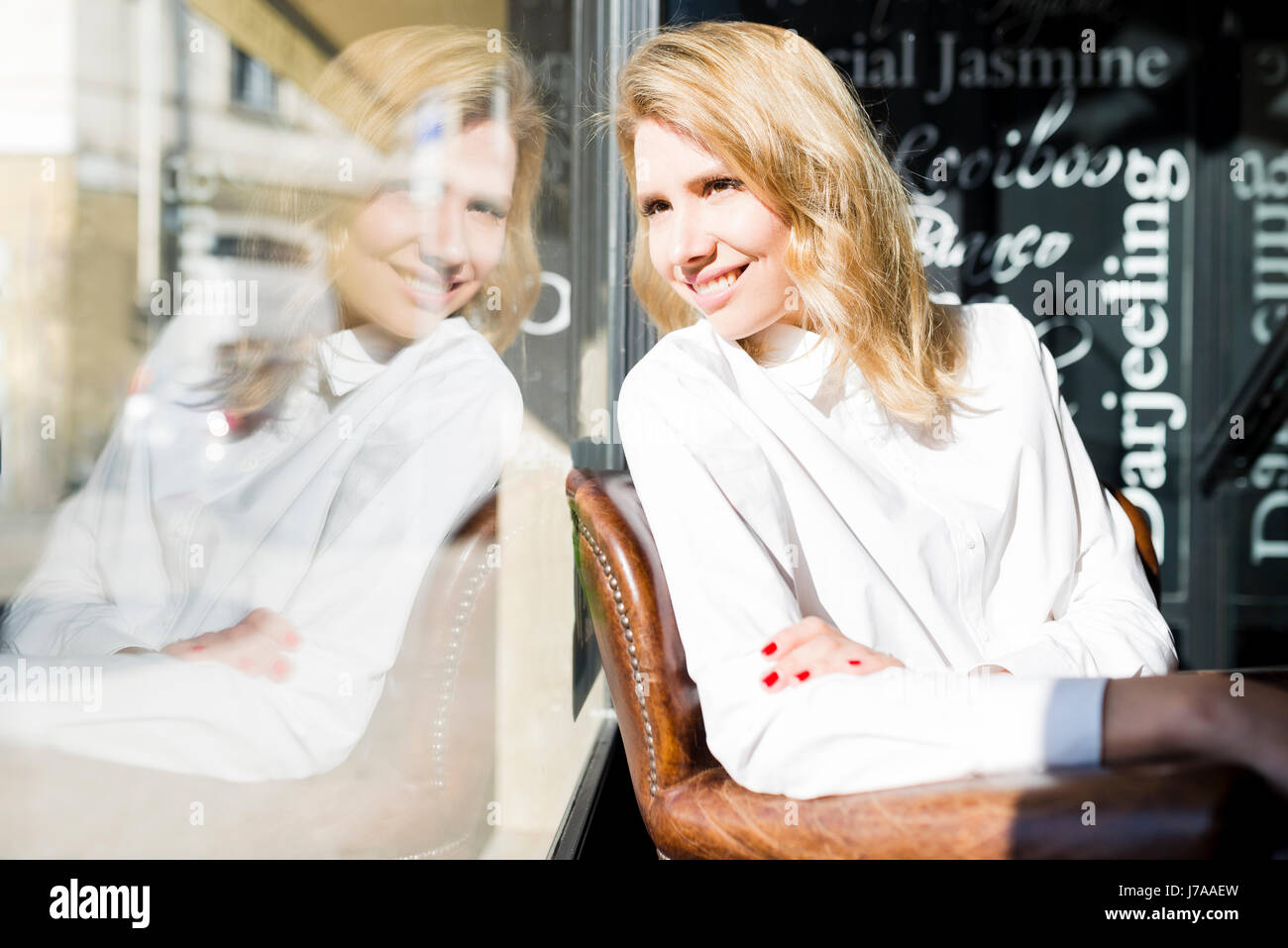 Smiling businesswoman in a cafe looking out of window Stock Photo - Alamy