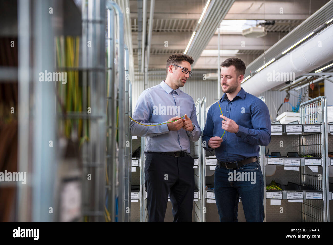 Two men in factory shop floor examining product Stock Photo - Alamy