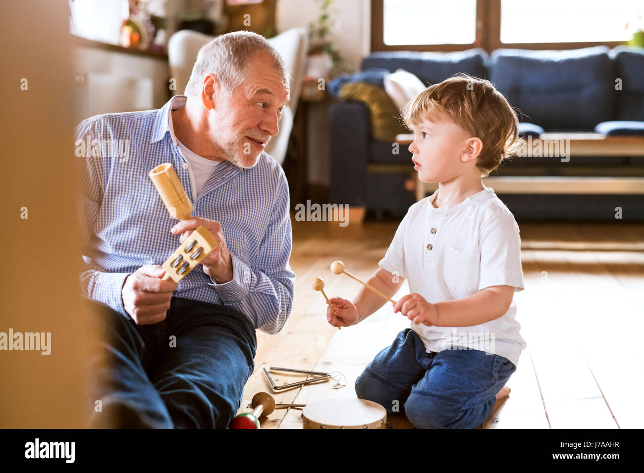 Grandfather and grandson playing music at home Stock Photo - Alamy