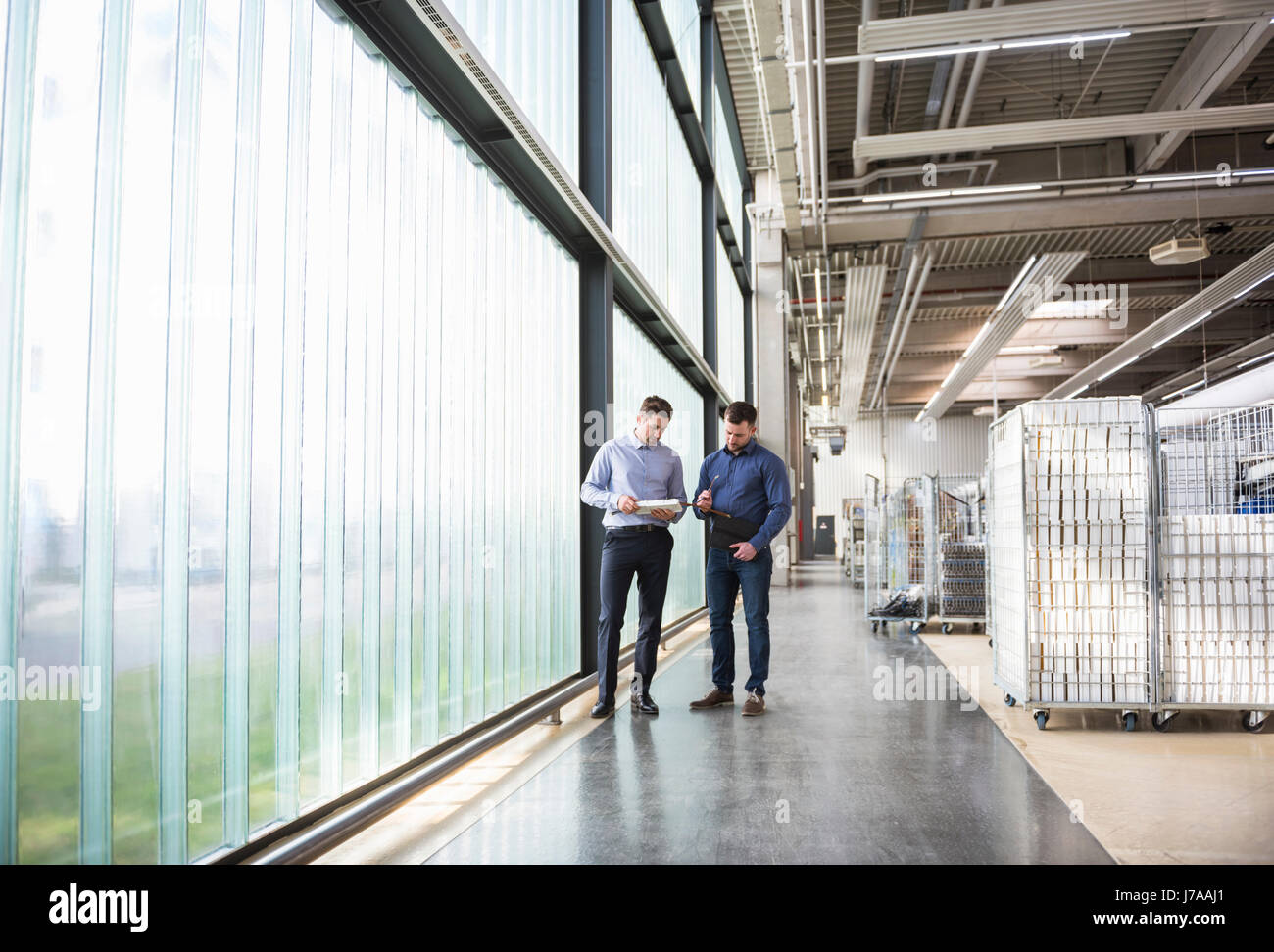 Two men in factory shop floor examining product Stock Photo - Alamy