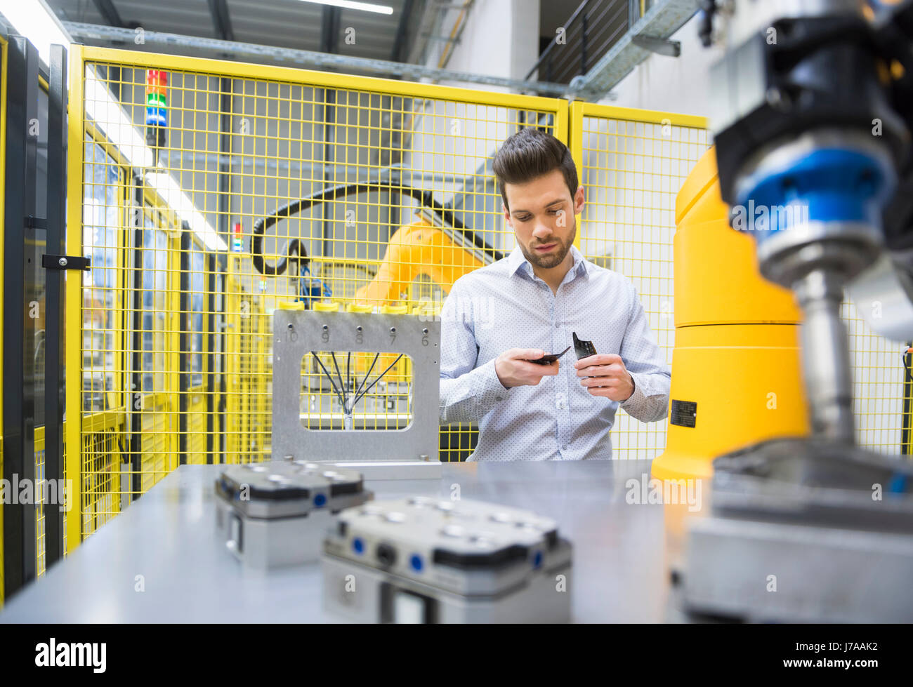 Young businessman checking automated production in factory Stock Photo ...