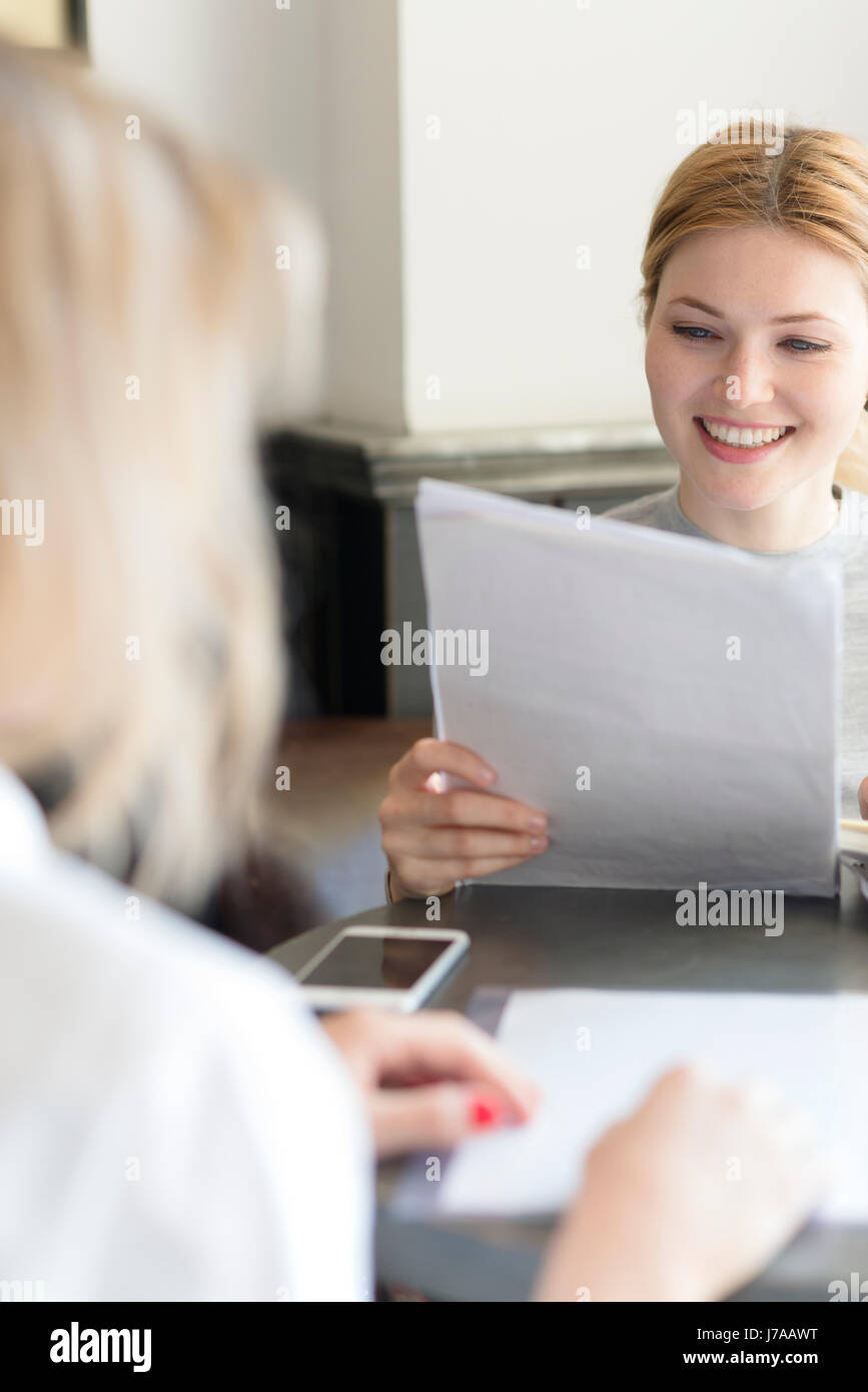 Smiling woman reading document Stock Photo - Alamy