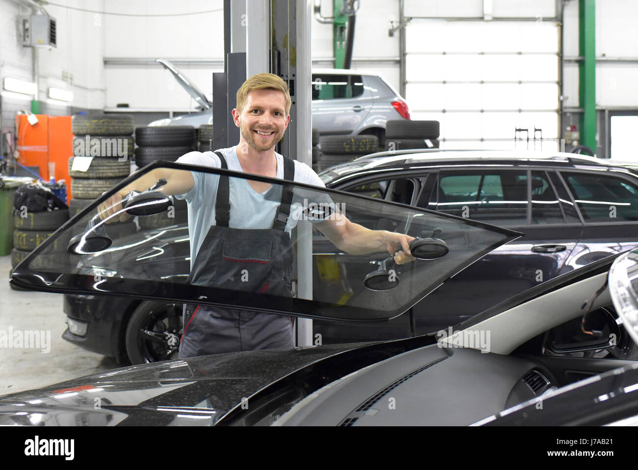 Car mechanic in a workshop changing car window Stock Photo - Alamy