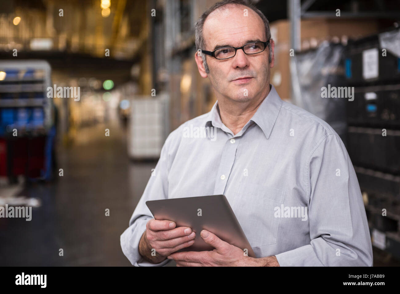 Man holding tablet in factory warehouse Stock Photo - Alamy