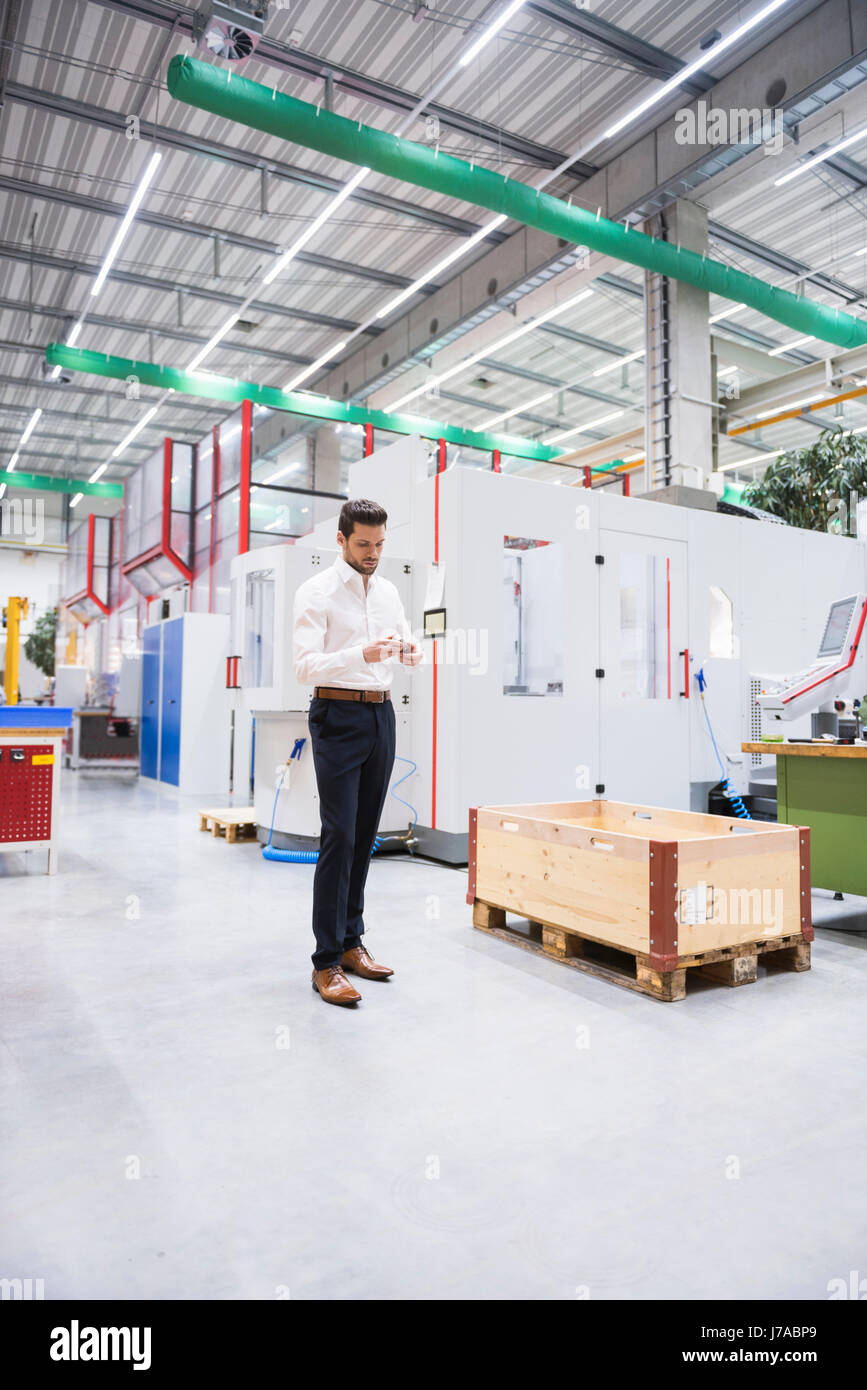 Man in factory shop floor holding product Stock Photo - Alamy