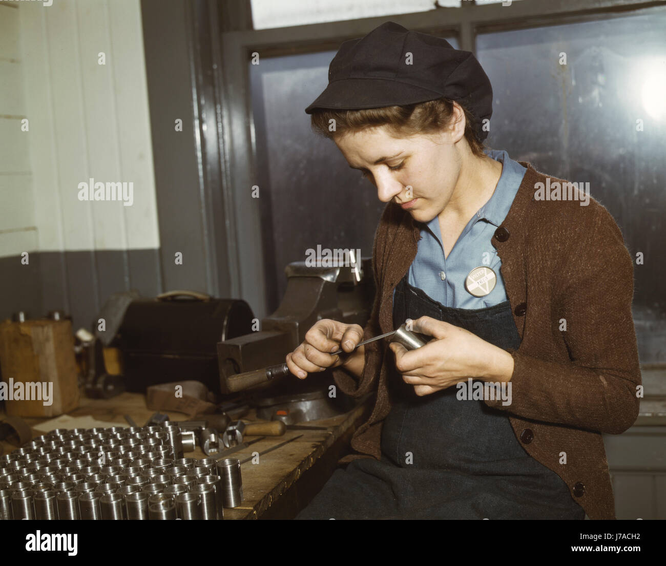Woman filing small gun parts in making M5 and M7 guns for the U.S. Army ...