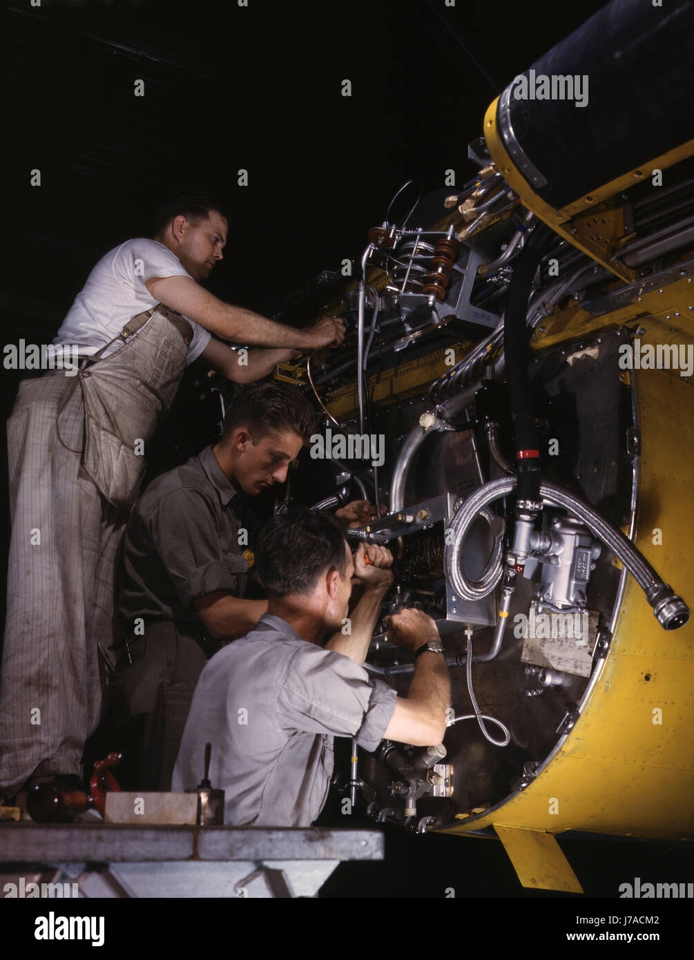 Workers wiring assemblies on the fire wall for the right engine of a B ...